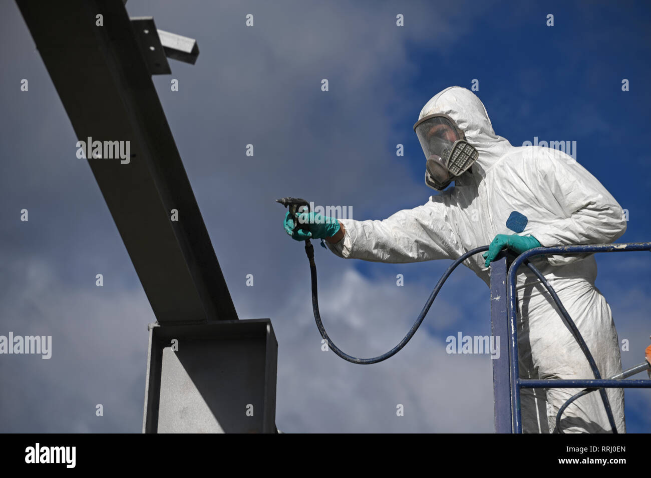 Tradesman spray paints the steel beams on a construction site Stock ...