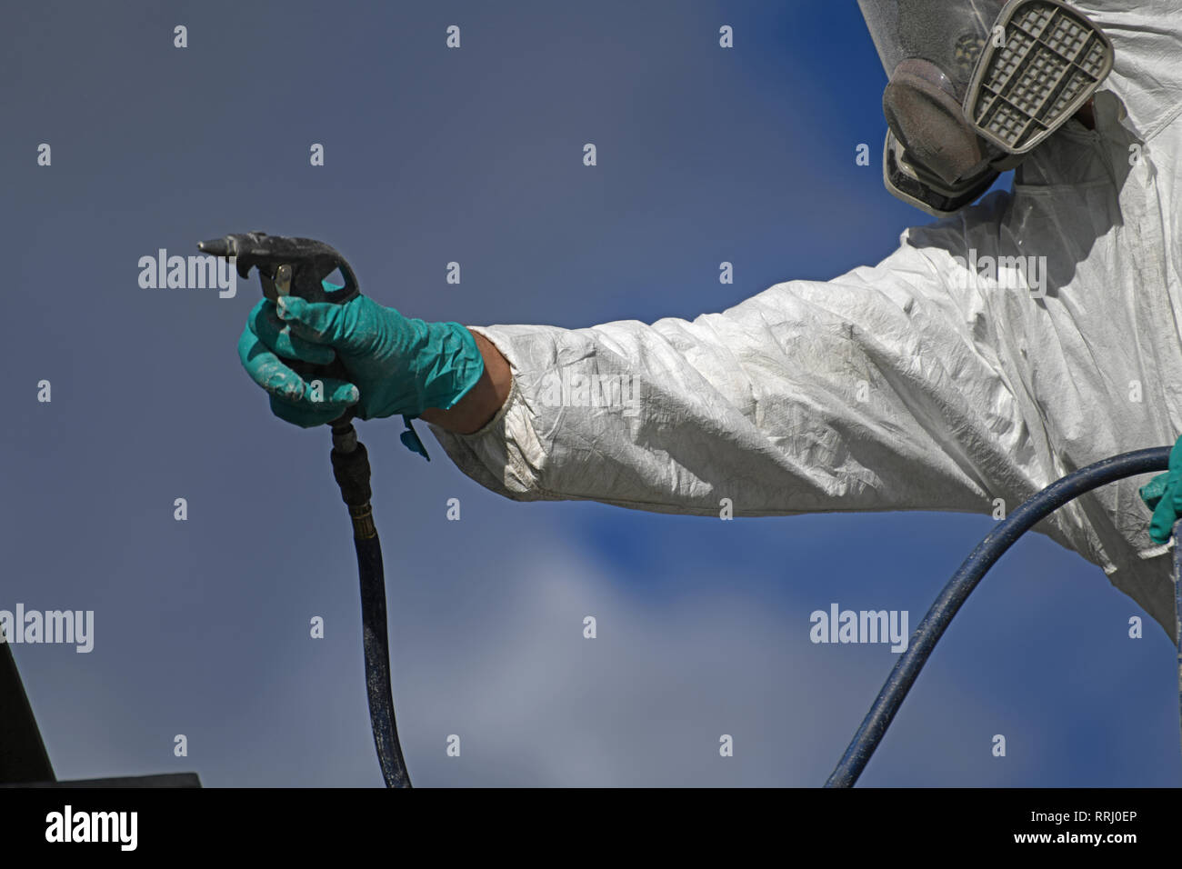 Detail of a tradesman spray painting the steel beams on a construction ...