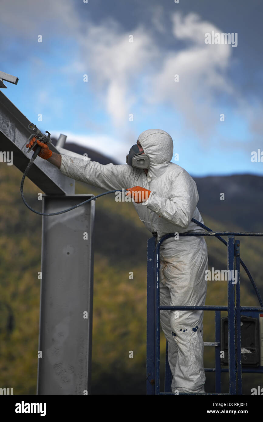 Tradesman spray paints the steel beams on a construction site Stock ...
