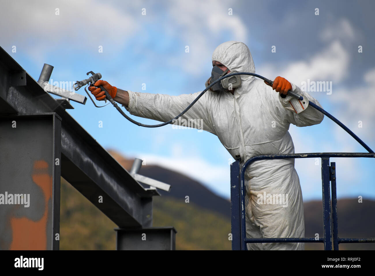 Tradesman spray paints the steel beams on a construction site Stock ...
