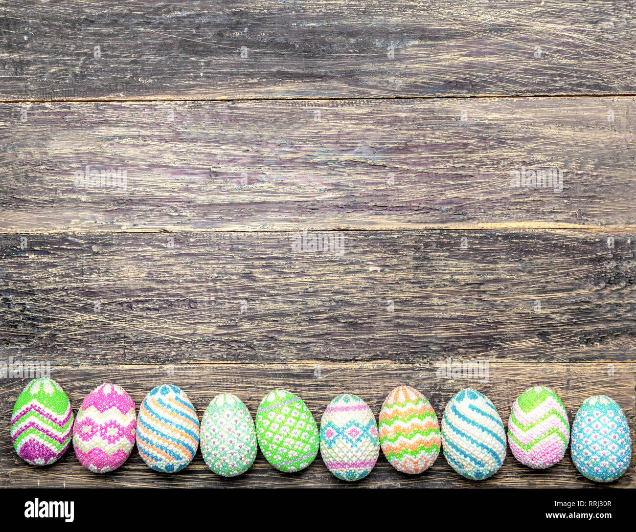 Row of Colorful easter eggs with copyspace on the wooden table. Happy ...