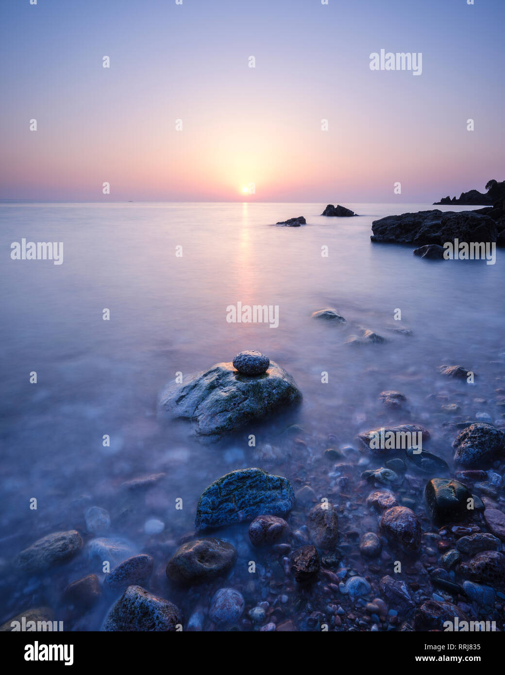 A colourful spring sunrise over Torbay with warm light glinting off the ...