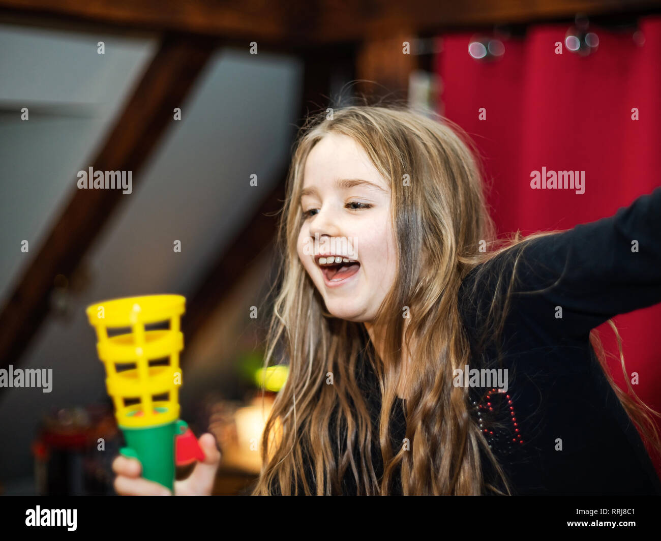 Cute little long haired girl playing games at home, hooligan type of ...