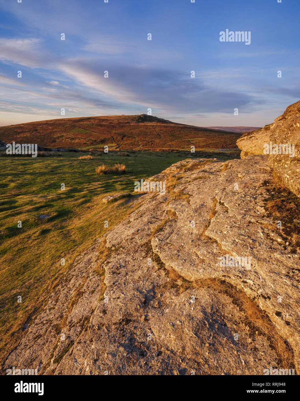 First sunlight on granite at the summit of Saddle Tor looking at Rippon ...