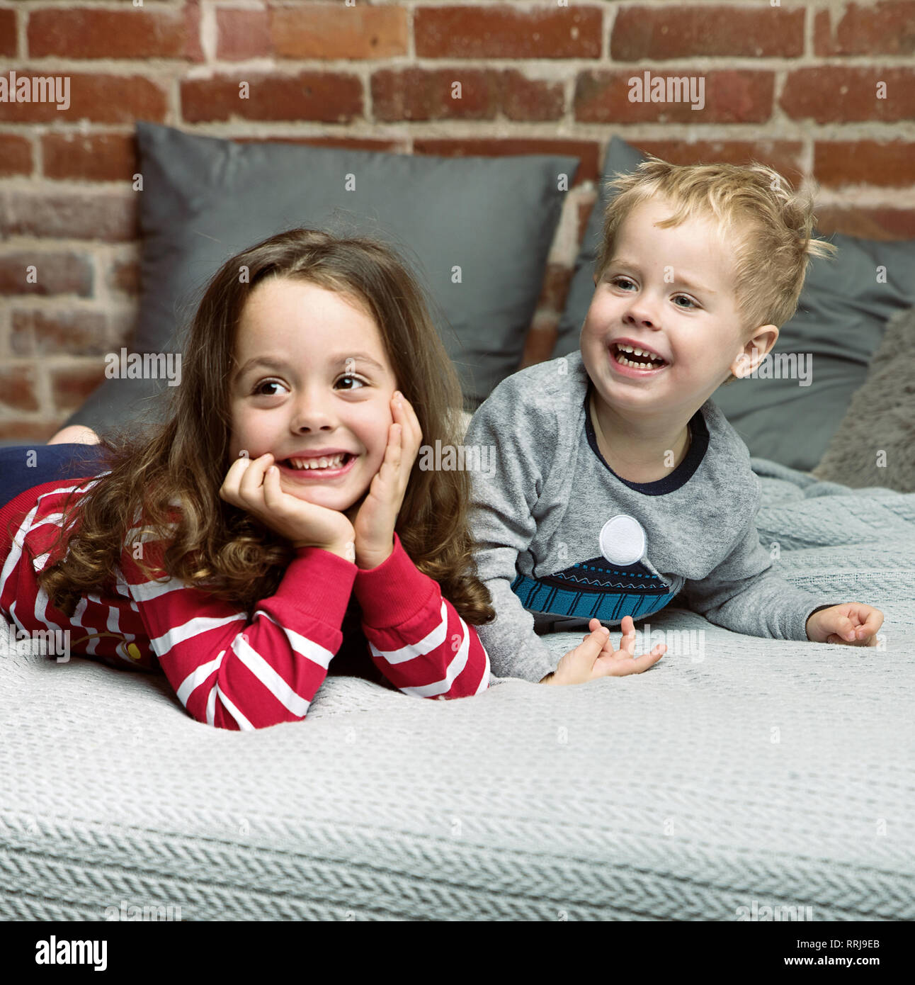 Portrait of joyful siblings relaxing in bedroom Stock Photo - Alamy