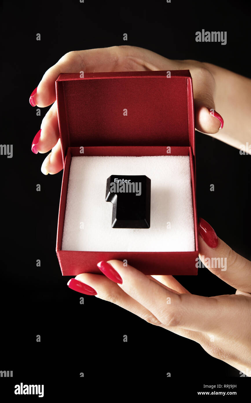 Conceptual photo of an "enter" button in a red gift box Stock Photo - Alamy