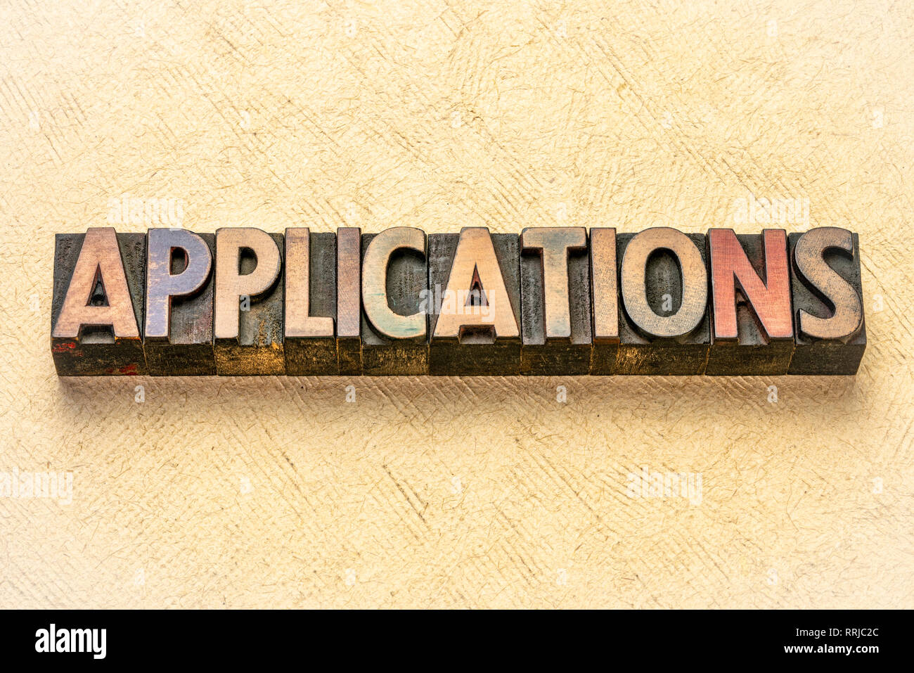 applications word in vintage letterpress wood type blocks against ...