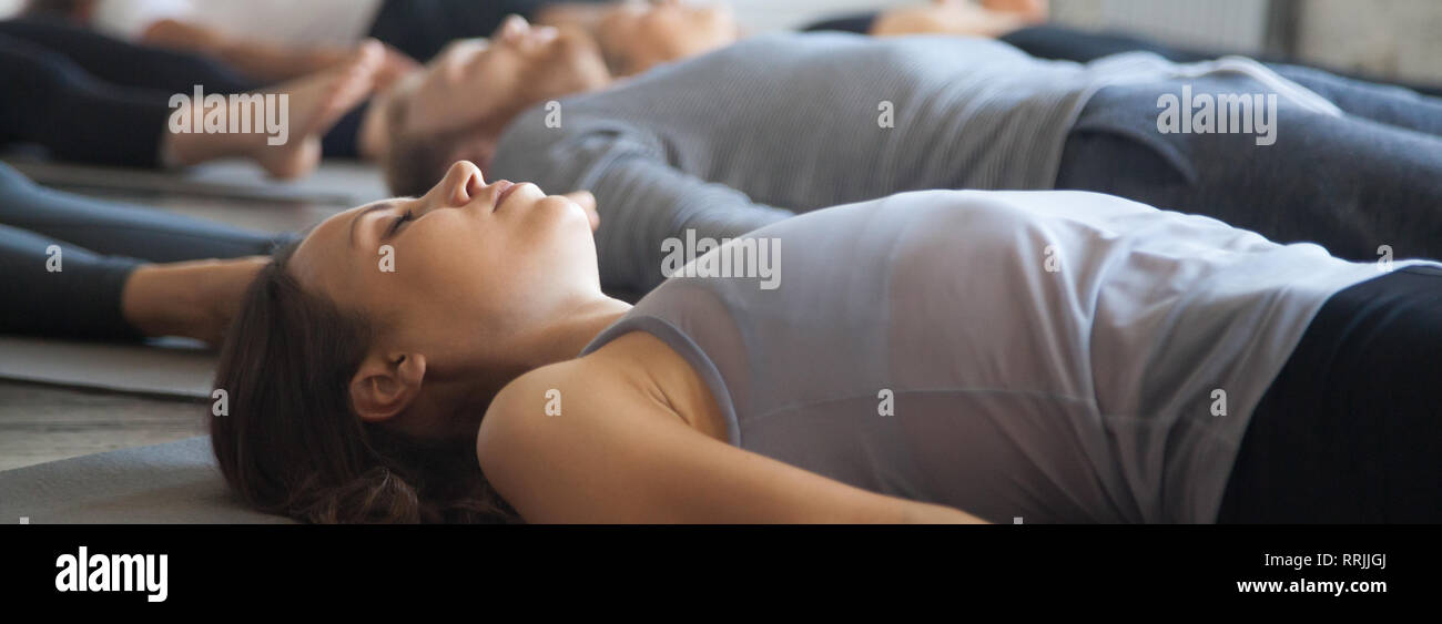 Horizontal image group yoga session people practice Savasana Corpse ...