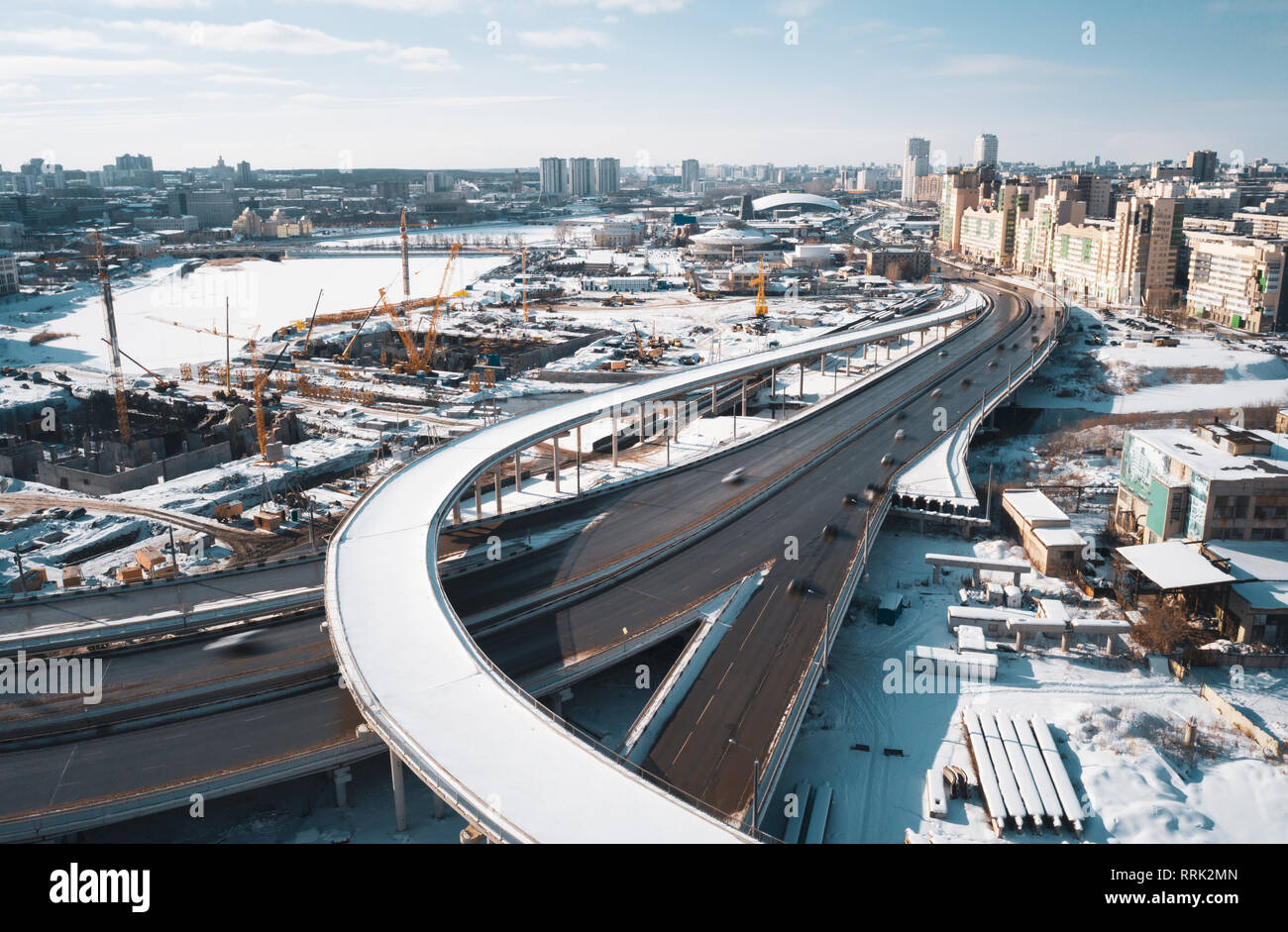 Aerial drone view of construction site; cranes and machines; new segment of road junction ...