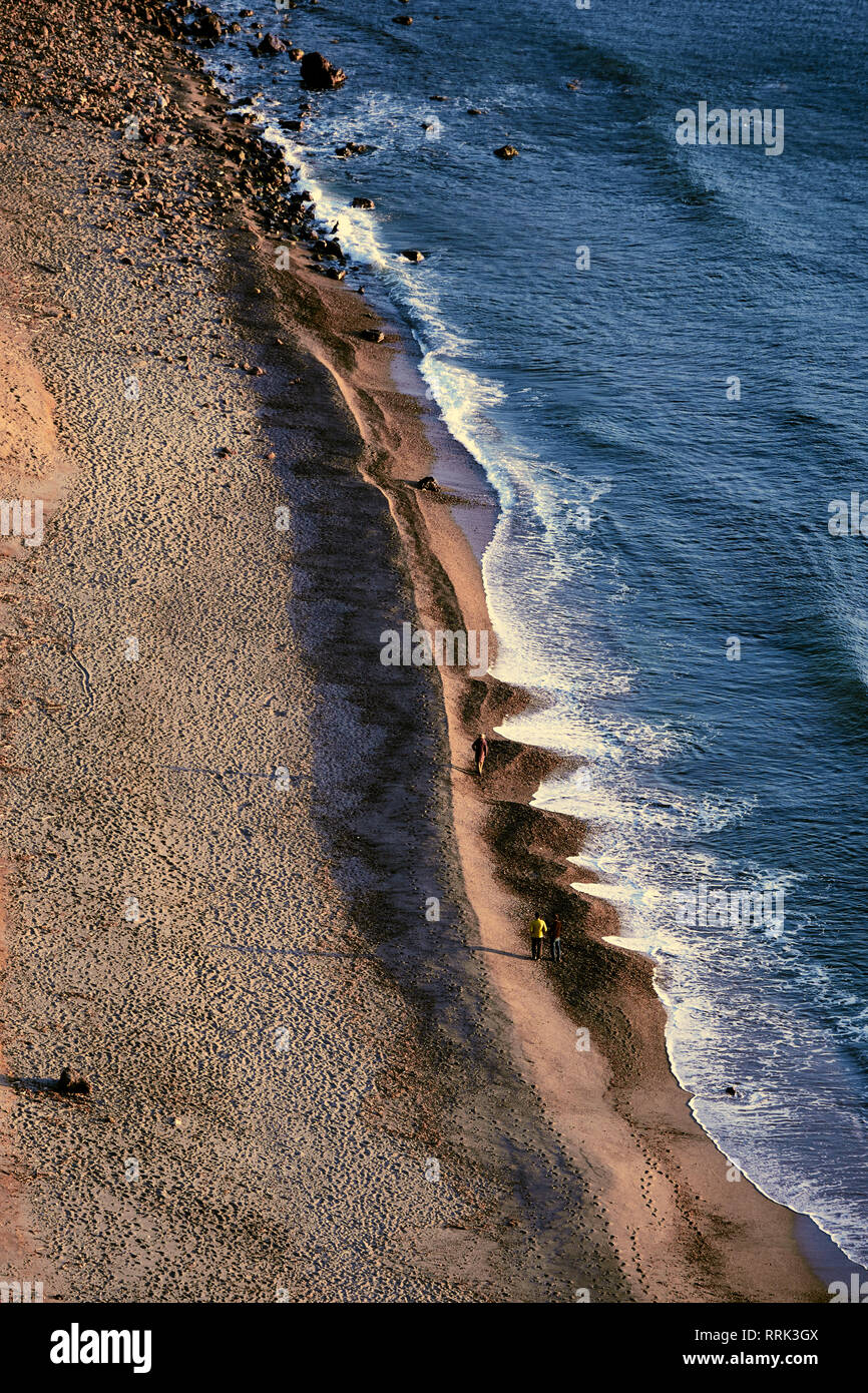 3 people walking on a lonely beach Stock Photo - Alamy
