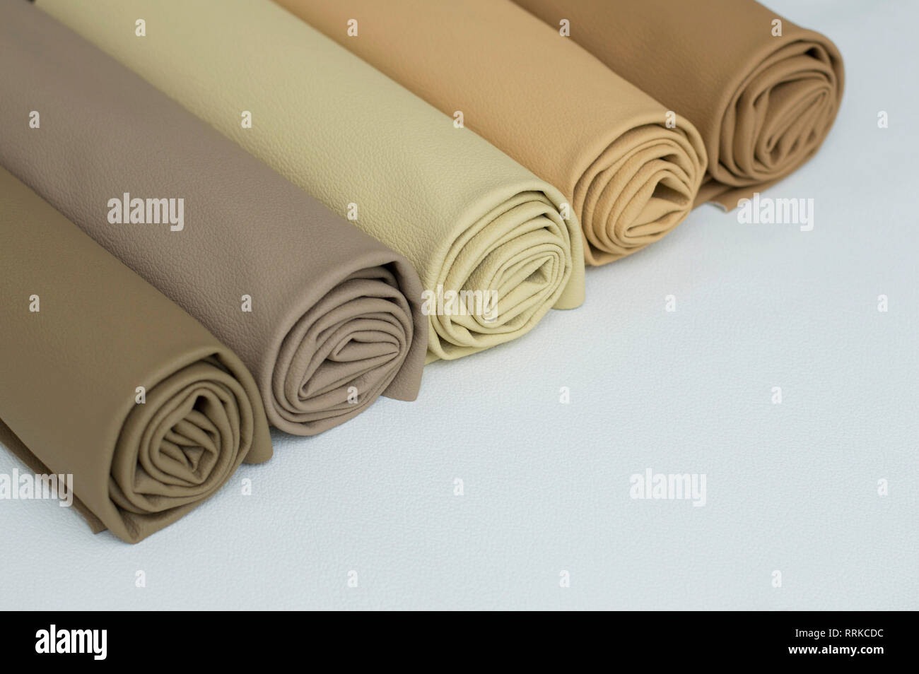 Leather rolls of brown color shades on white background Stock Photo - Alamy