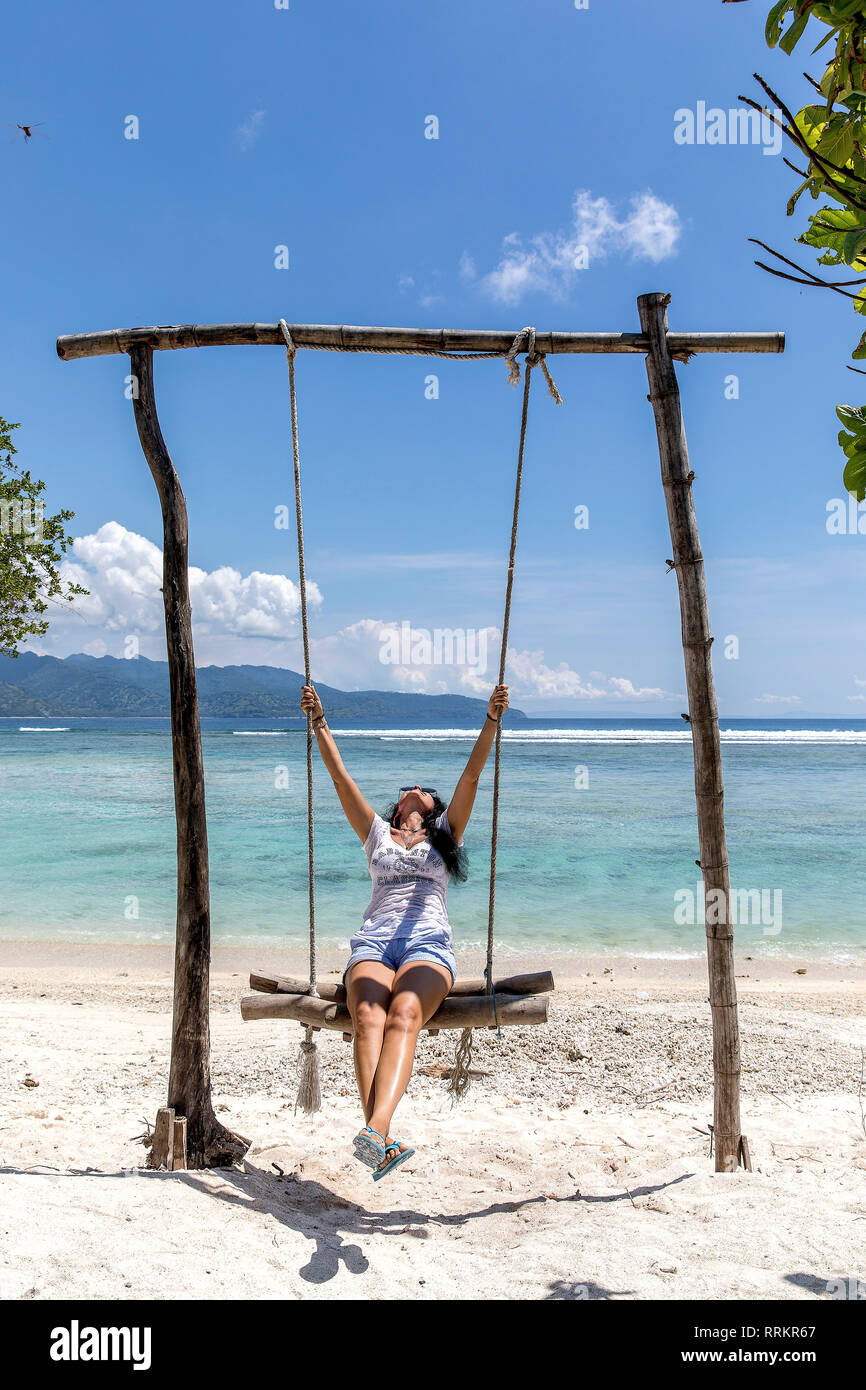 indonesia, gili trawangan island Young woman swinging on swing Stock ...