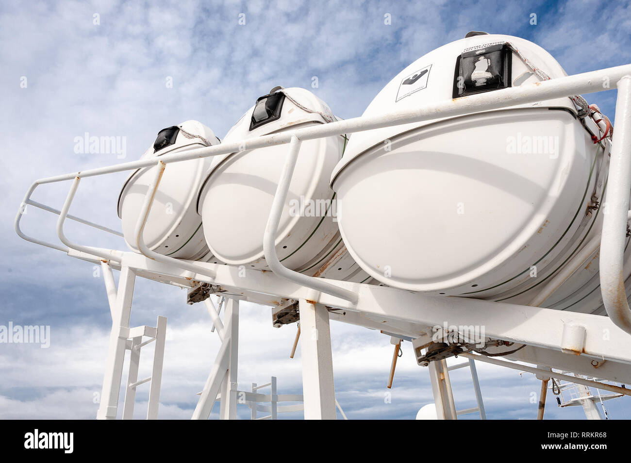 Life rafts on board a passenger ferry. Upwards view of three lifeboat ...