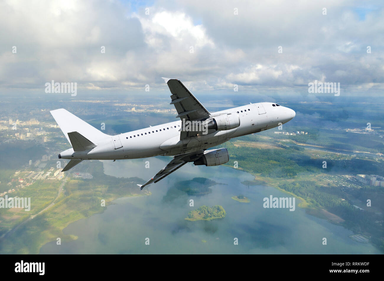 White airplane flying in the sky among white dense clouds floating over ...