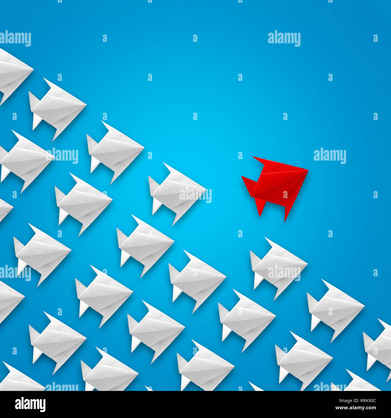 Flying paper fish origami with a red one on blue background. Business ...