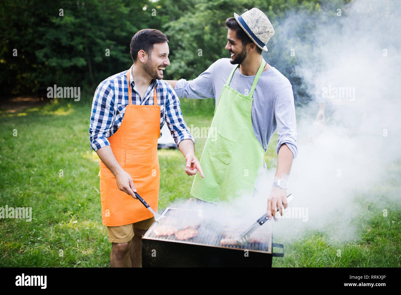 Group of friends making barbecue in the nature Stock Photo - Alamy