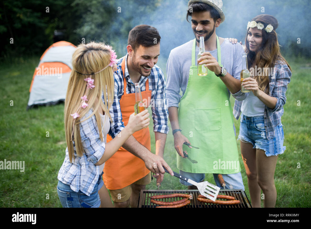 Happy group of friends making a barbecue together outdoors in the ...