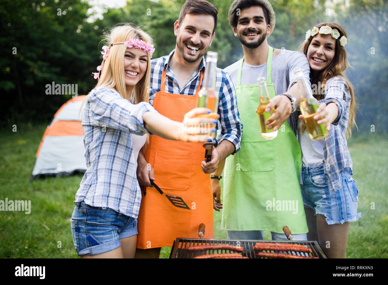 Group of friends making a barbecue together outdoors in the nature ...