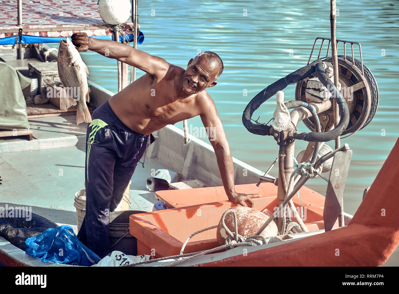 Langkawi, Malaysia - Dec 18: Asian fisherman with fish in hand. Hand ...