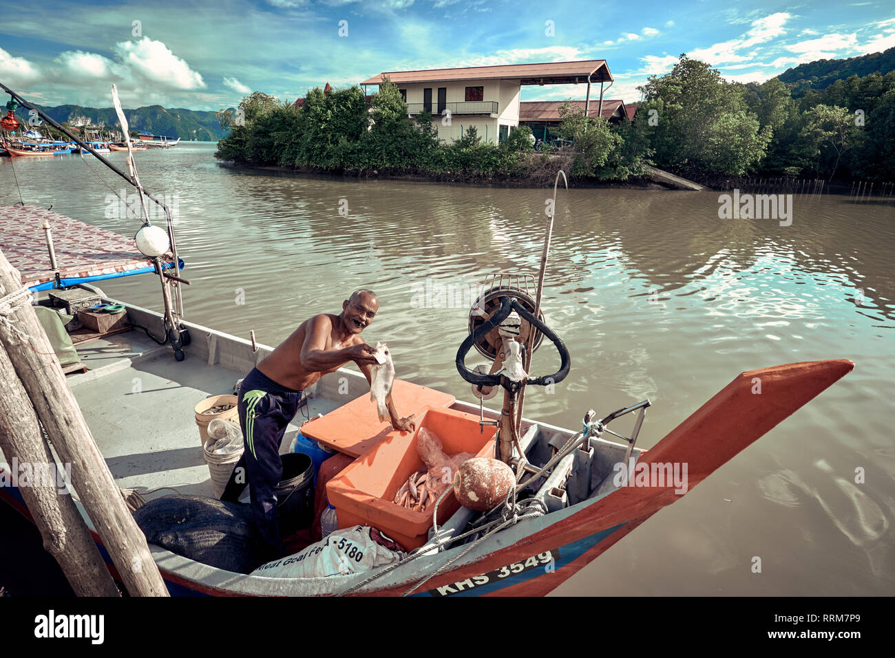 Langkawi, Malaysia - Dec 18: Asian fisherman with fish in hand. Hand ...