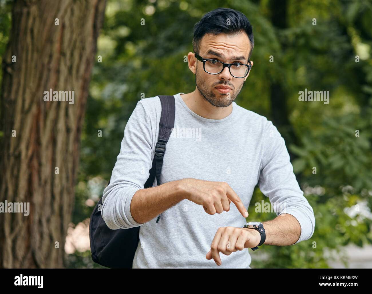 Young businessman points to his watch on arm Stock Photo - Alamy
