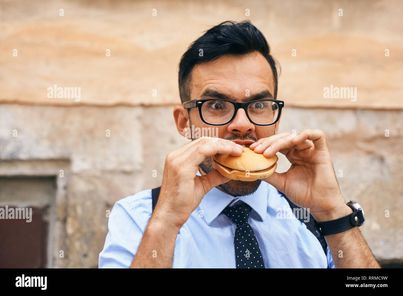 Beautiful Young businessman eating a burger Stock Photo - Alamy