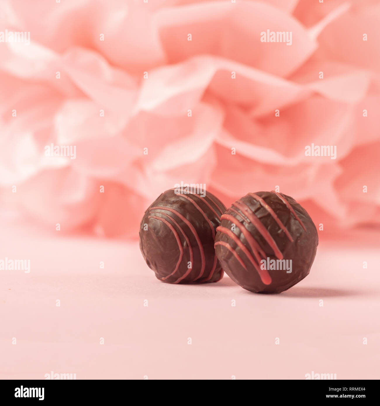 Round candy cane on a delicate pink coral background in the form of a ...