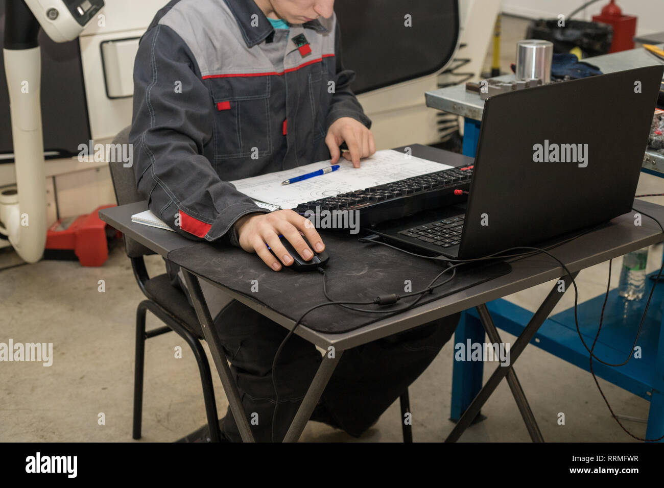Man doing computer work and writing down the notes and drawng schemes ...