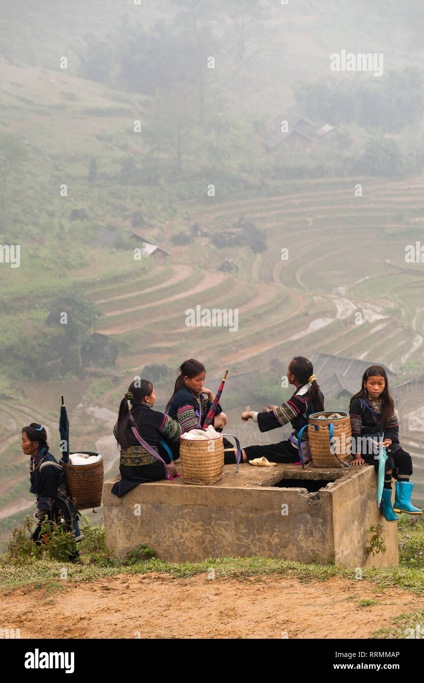 Local Hmong women in traditional clothes sit talking with terraced ...