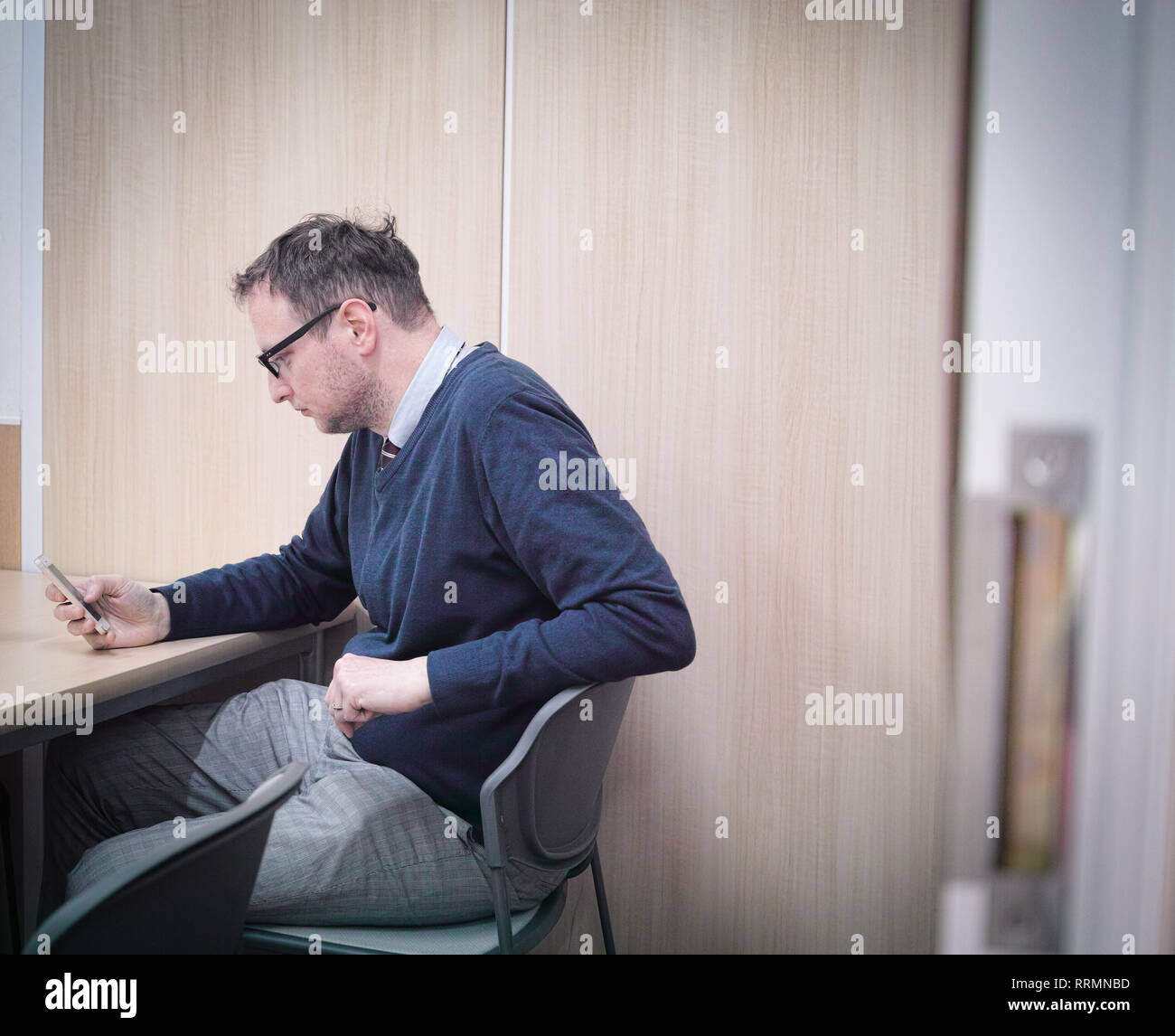 A man looking at his phone while killing time in his break Stock Photo ...