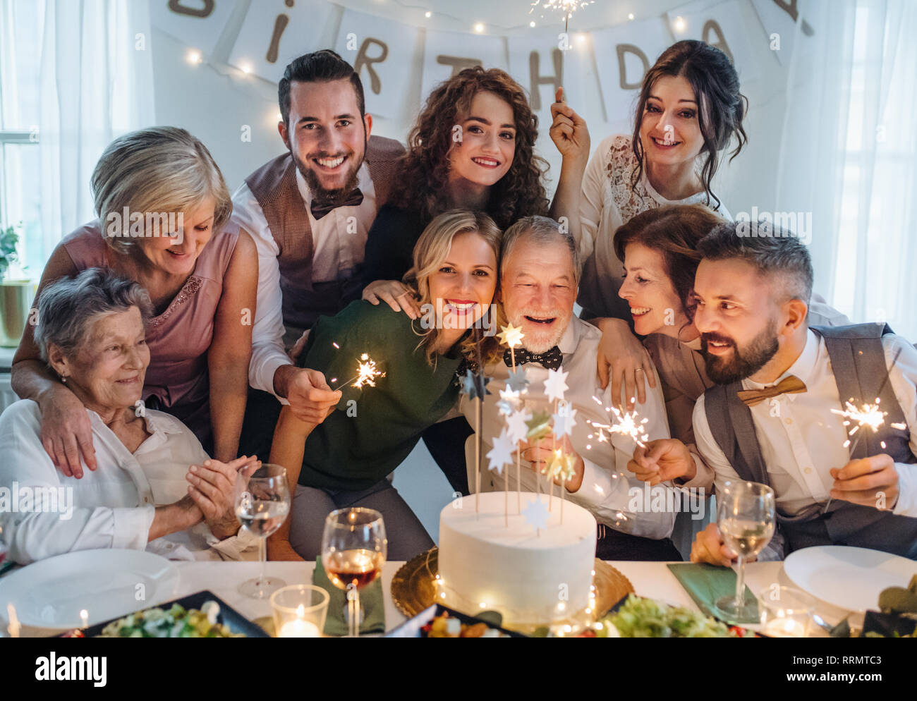 A senior man with multigeneration family and a cake celebrating ...