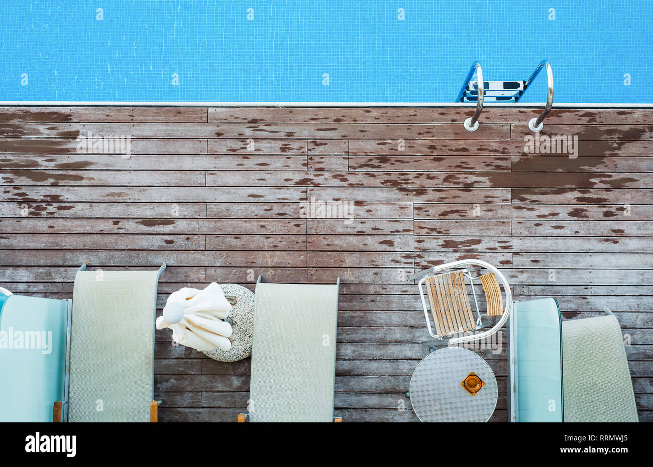 A top view of sunbathing deck and private swimming pool near beach ...