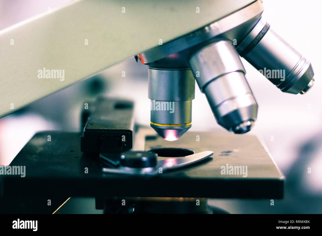 side view of a light microscope showing the light on and optical eye ...