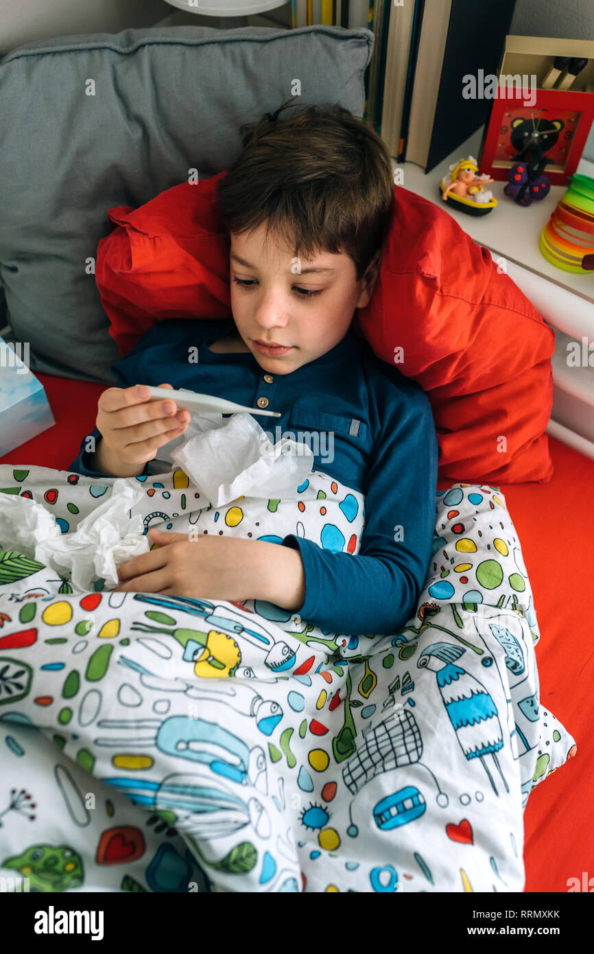 Cold child looking at the thermometer Stock Photo - Alamy