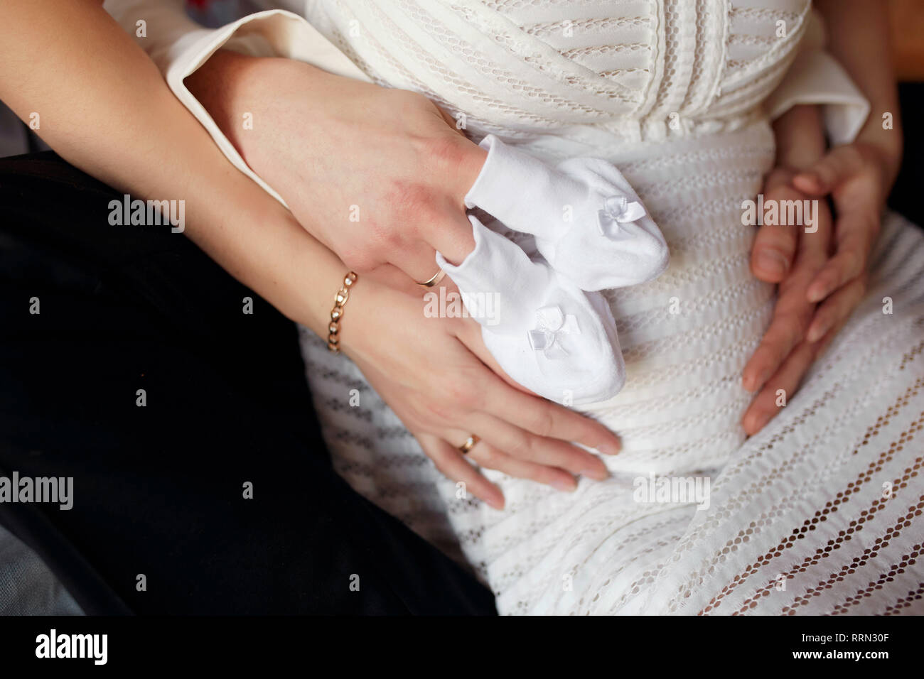 Young couple expecting baby hugging stomach Stock Photo - Alamy