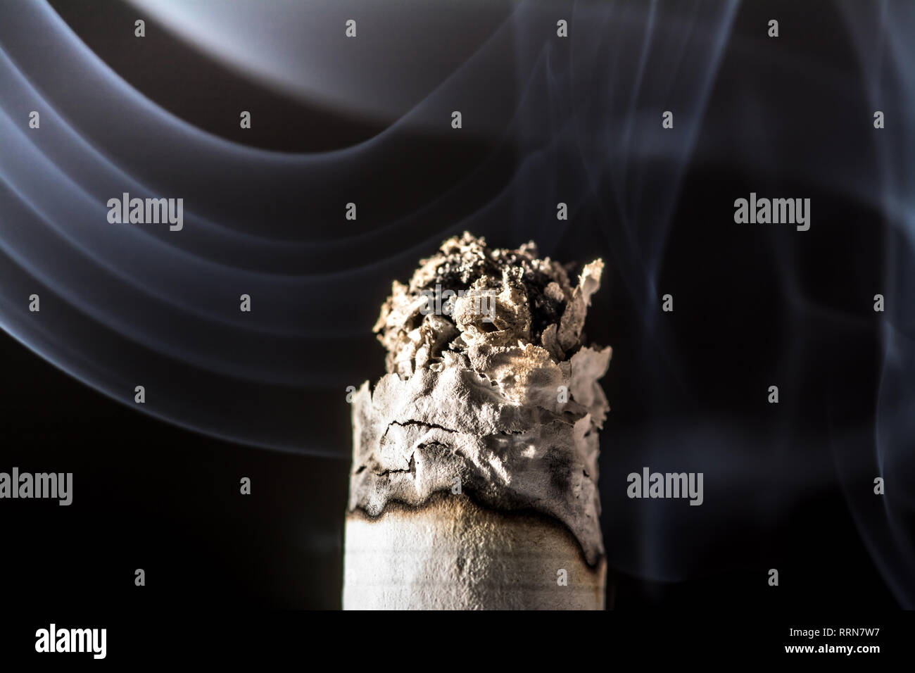 Burning smoldering cigarette close-up with beautiful smoke isolated on ...
