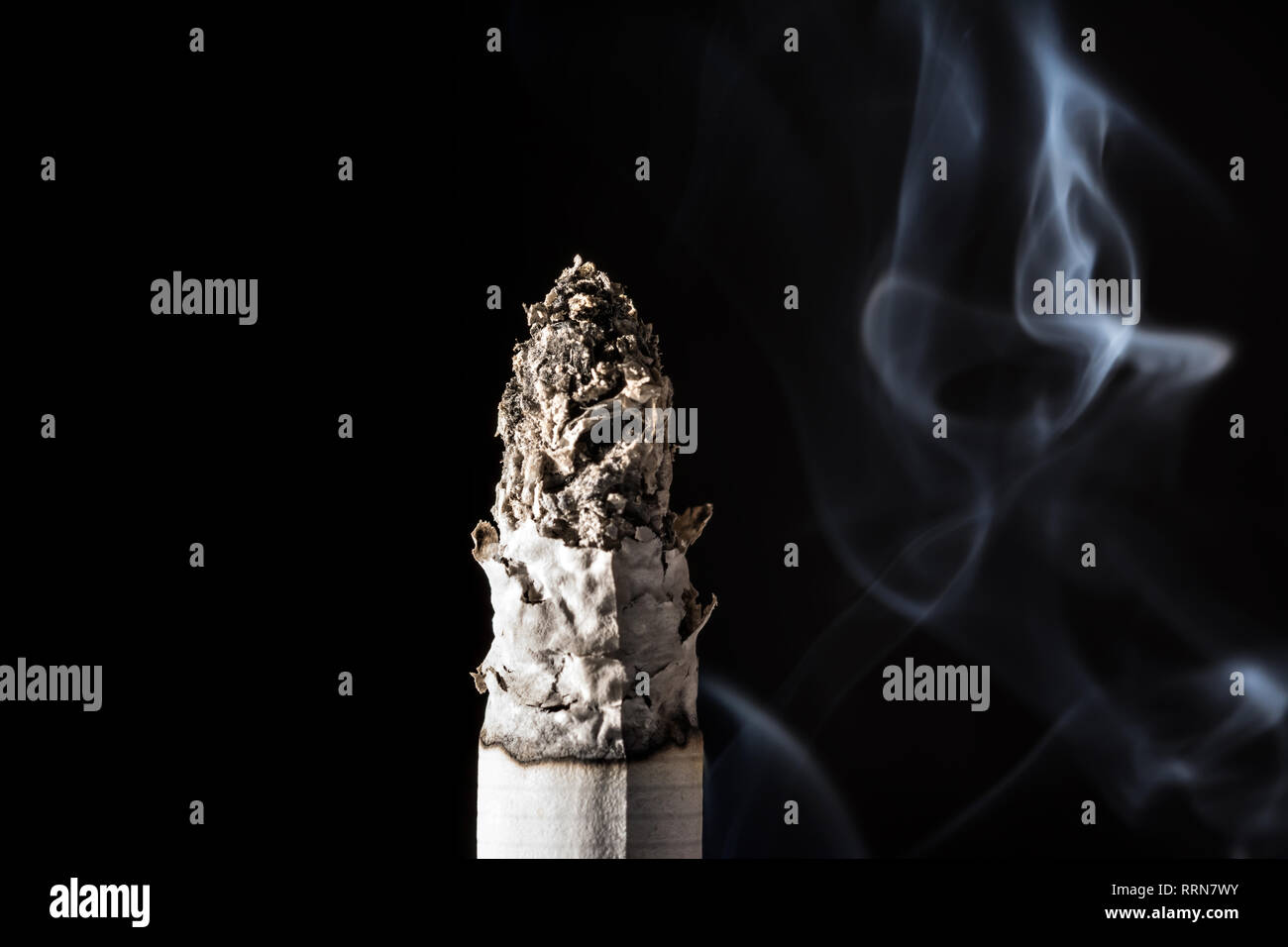 Burning smoldering cigarette close-up with beautiful smoke isolated on ...