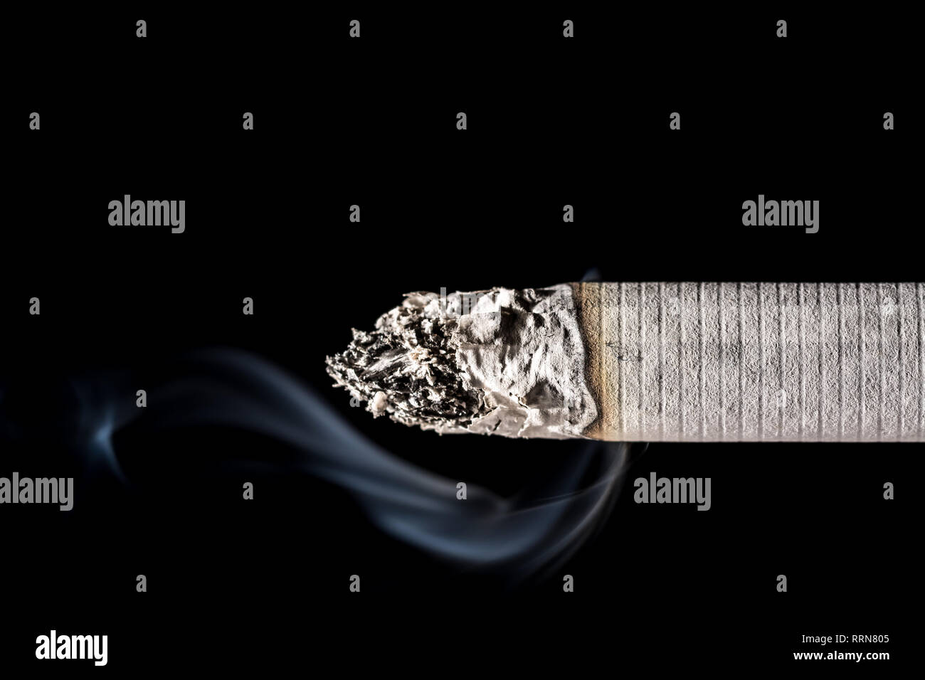 Burning smoldering cigarette close-up with beautiful smoke isolated on ...