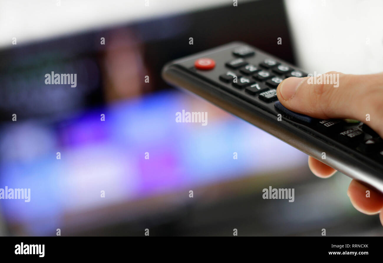 Hand holding remote control: binge watching a TV show Stock Photo - Alamy