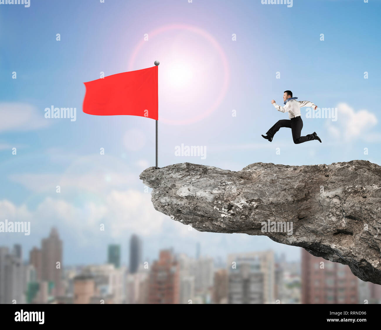 Man running for wavy red flag on cliff with city view in sunny day ...