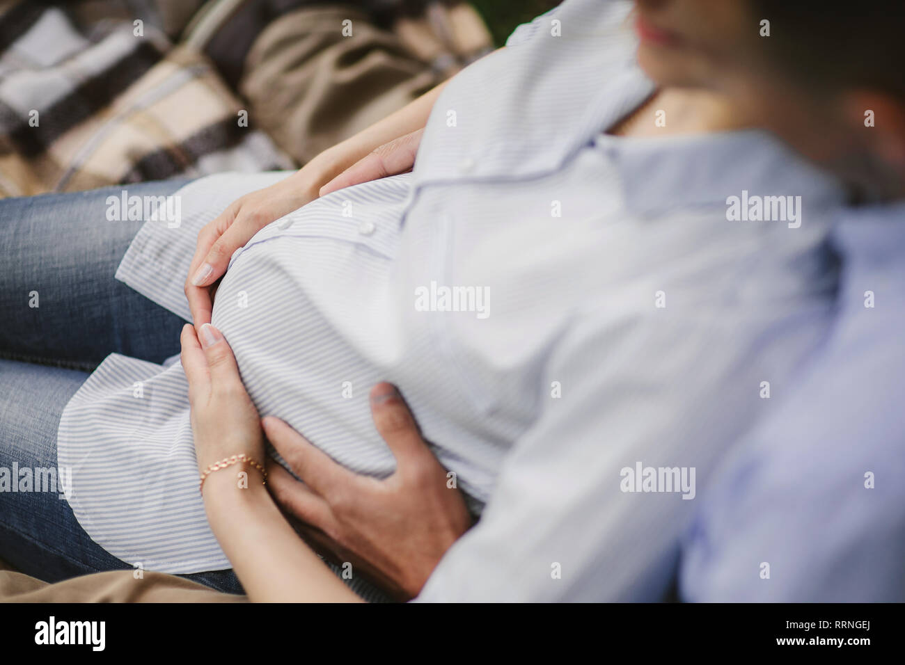 Young couple expecting baby hugging stomach Stock Photo - Alamy