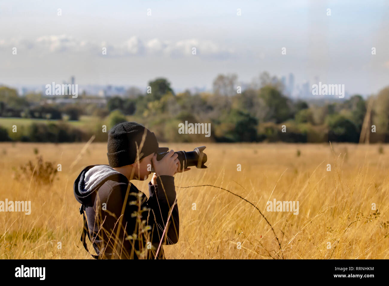 Teenage boy taking photos with digital single lens reflex camera in a ...