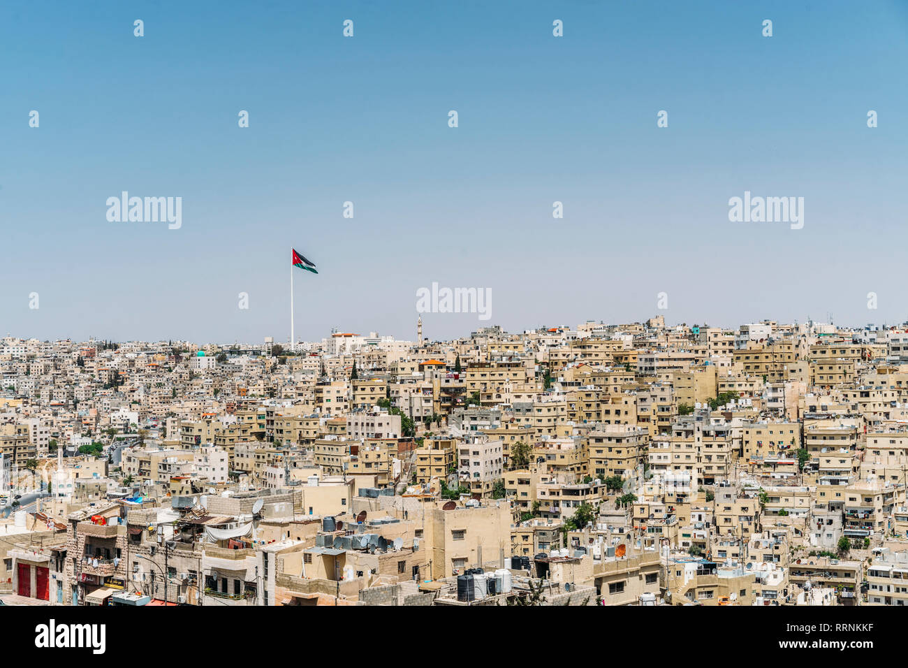 Jordanian flag flying over sunny city buildings, Amman, Jordan Stock ...