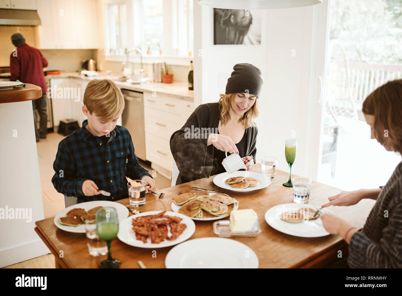 Family eating breakfast at kitchen table Stock Photo - Alamy