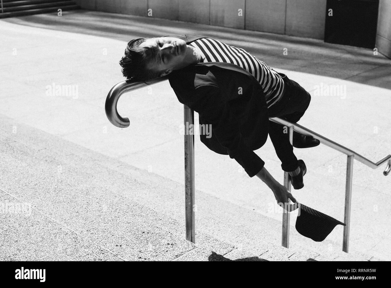 Portrait young man leaning on urban railing Stock Photo - Alamy