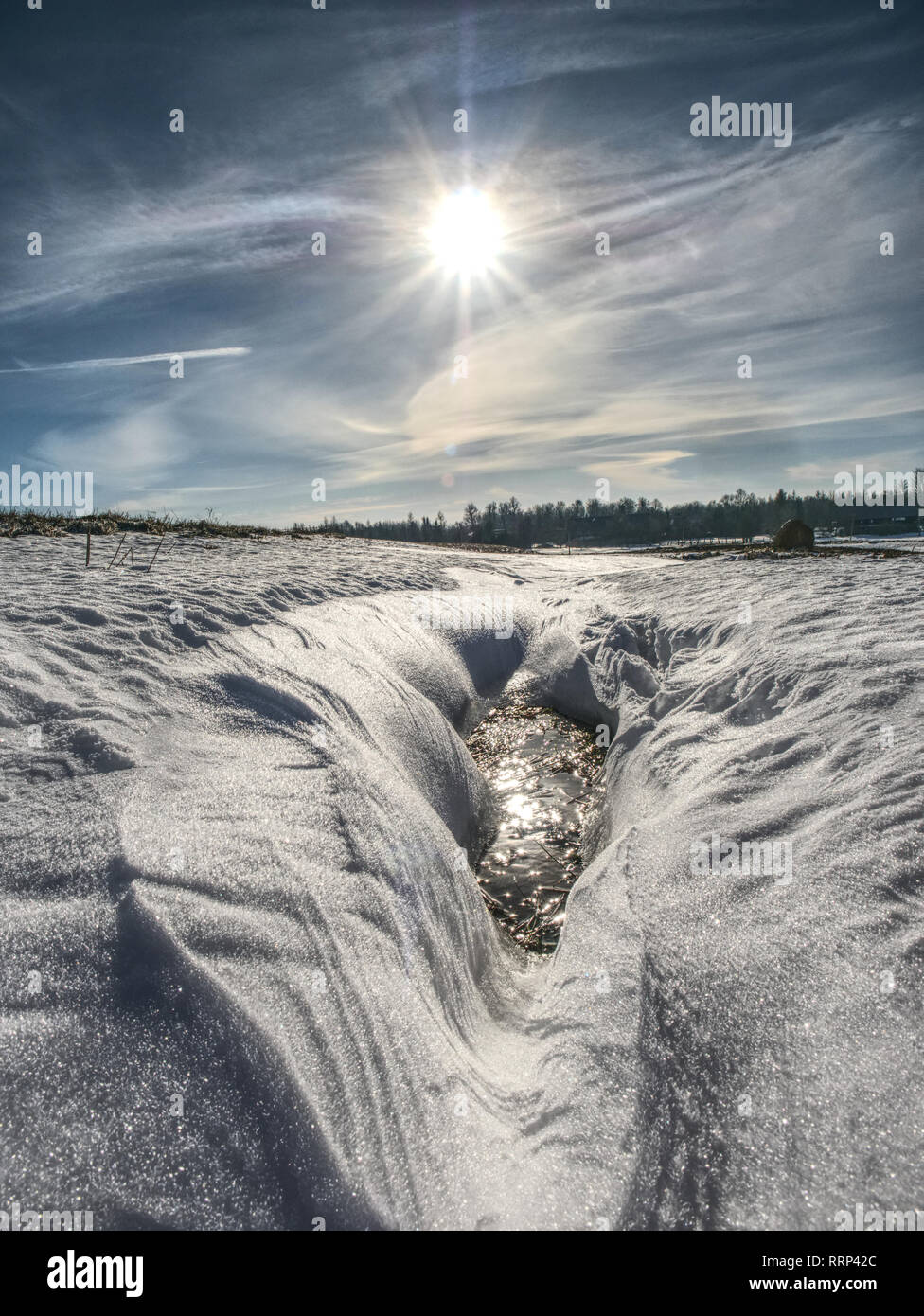 Hole in icy snow with sun flares. Lovely winter scene Stock Photo - Alamy