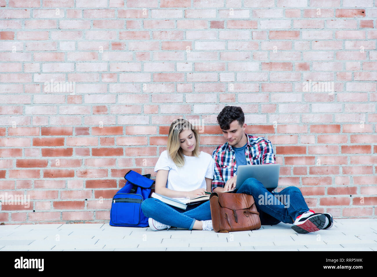 German male and female student with copy space outdoor on campus of ...