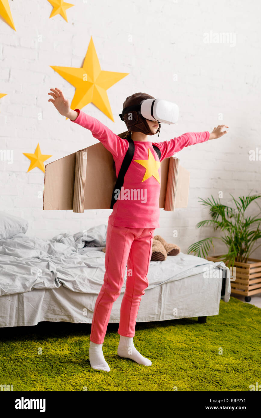 Full length view of kid in vr headset waving hands in bedroom Stock ...