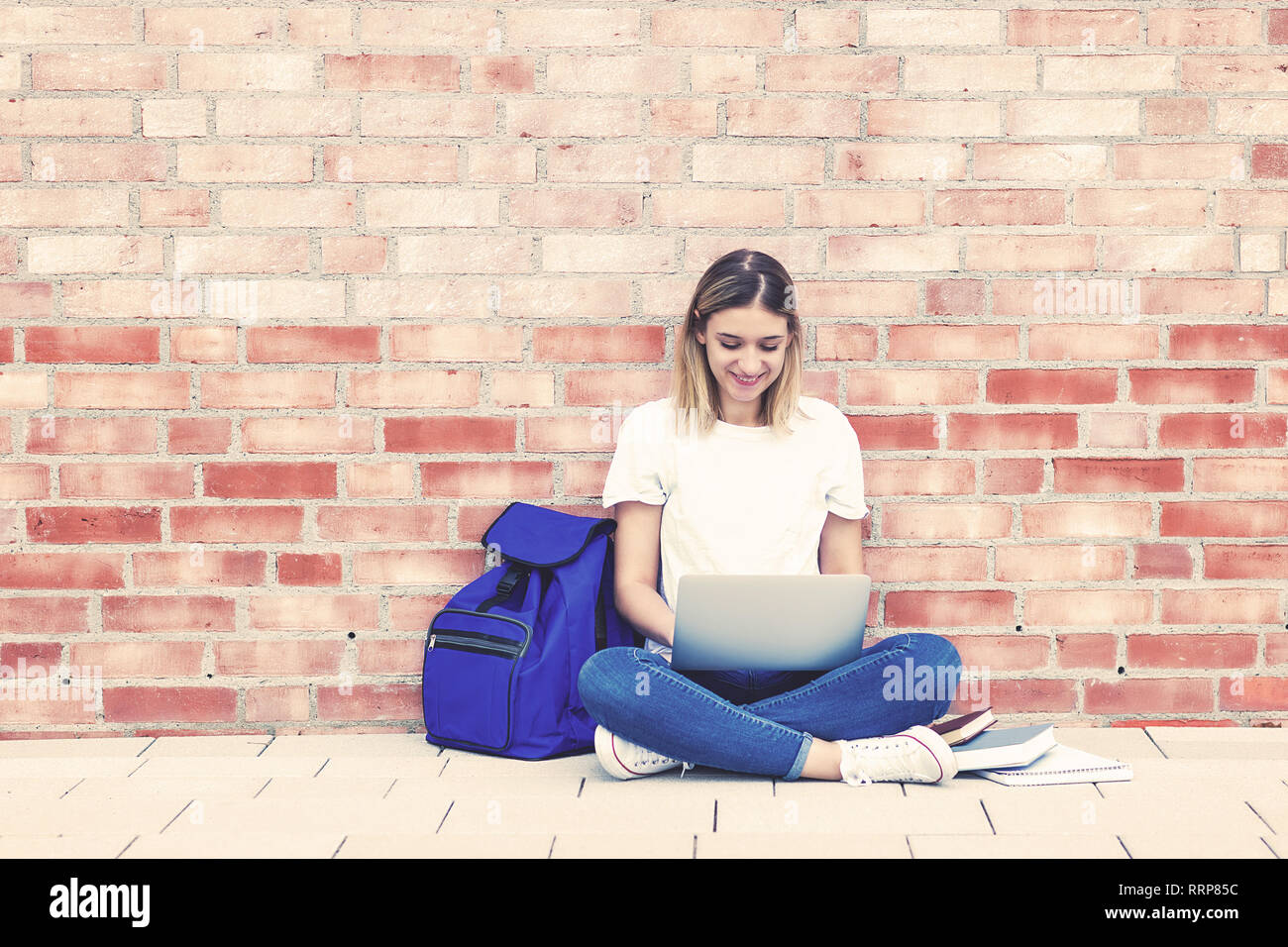 Beautiful german female student learning at computer outdoor on campus ...