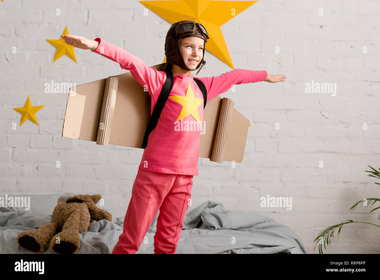 Inspired child with cardboard wings gesturing in bedroom Stock Photo ...